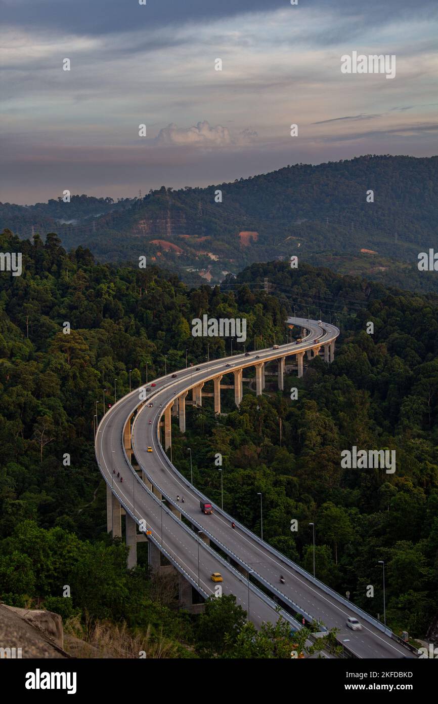 A vertical shot of Rawang Bypass highway amid green forest with dense ...