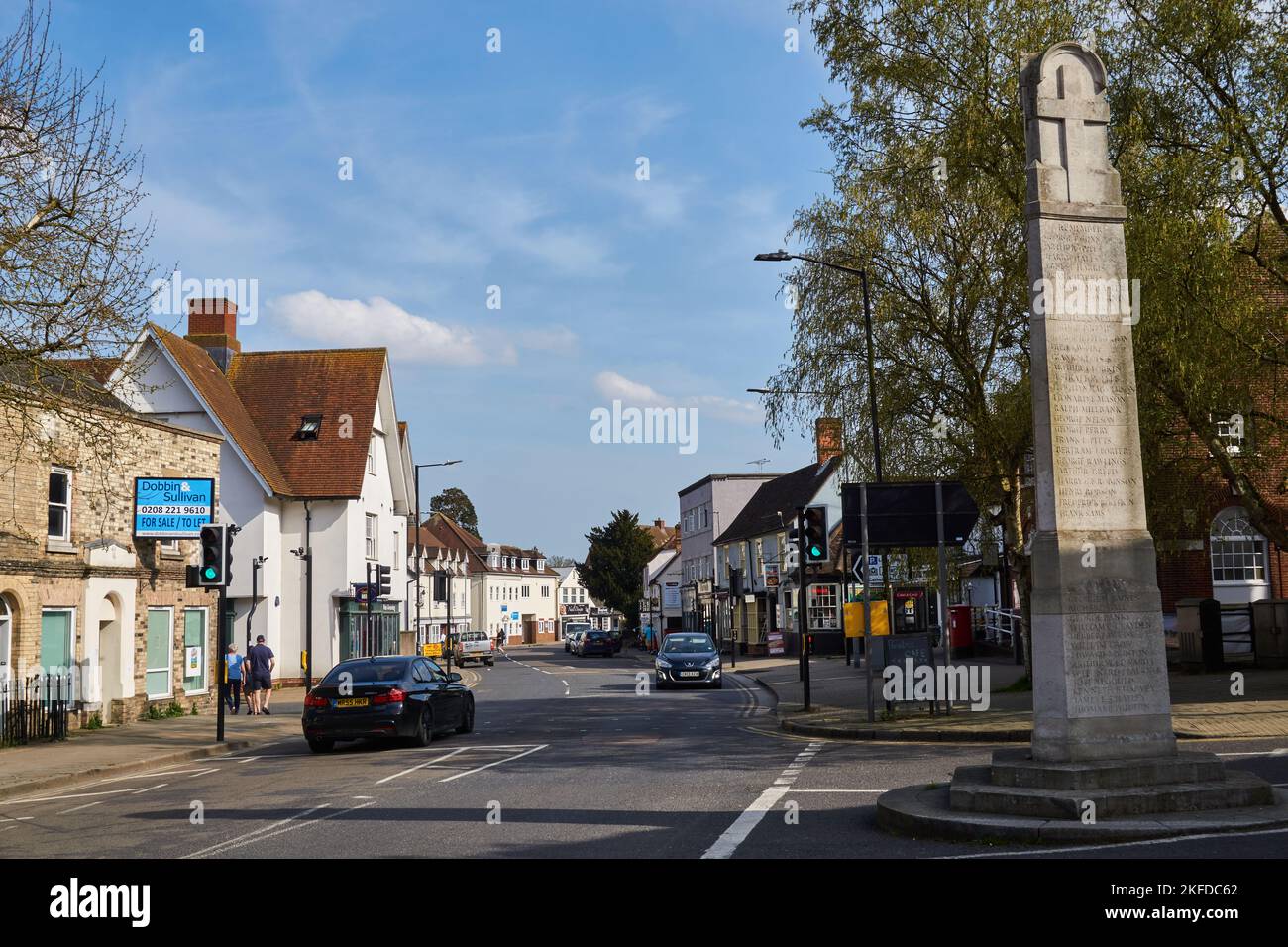 Quiet high street with cars stopped at the traffic lights next the ...
