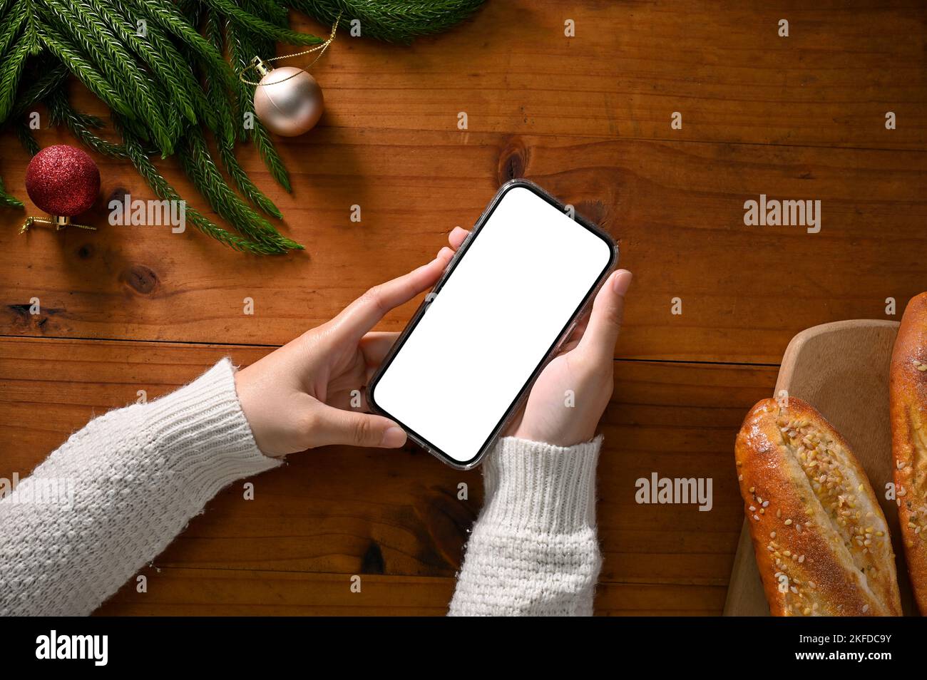 Top view, A female hands holding a smartphone white screen mockup over ...