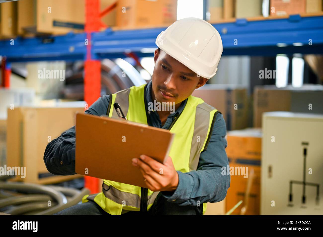 Concentrated and handsome millennial Asian male warehouse worker in ...