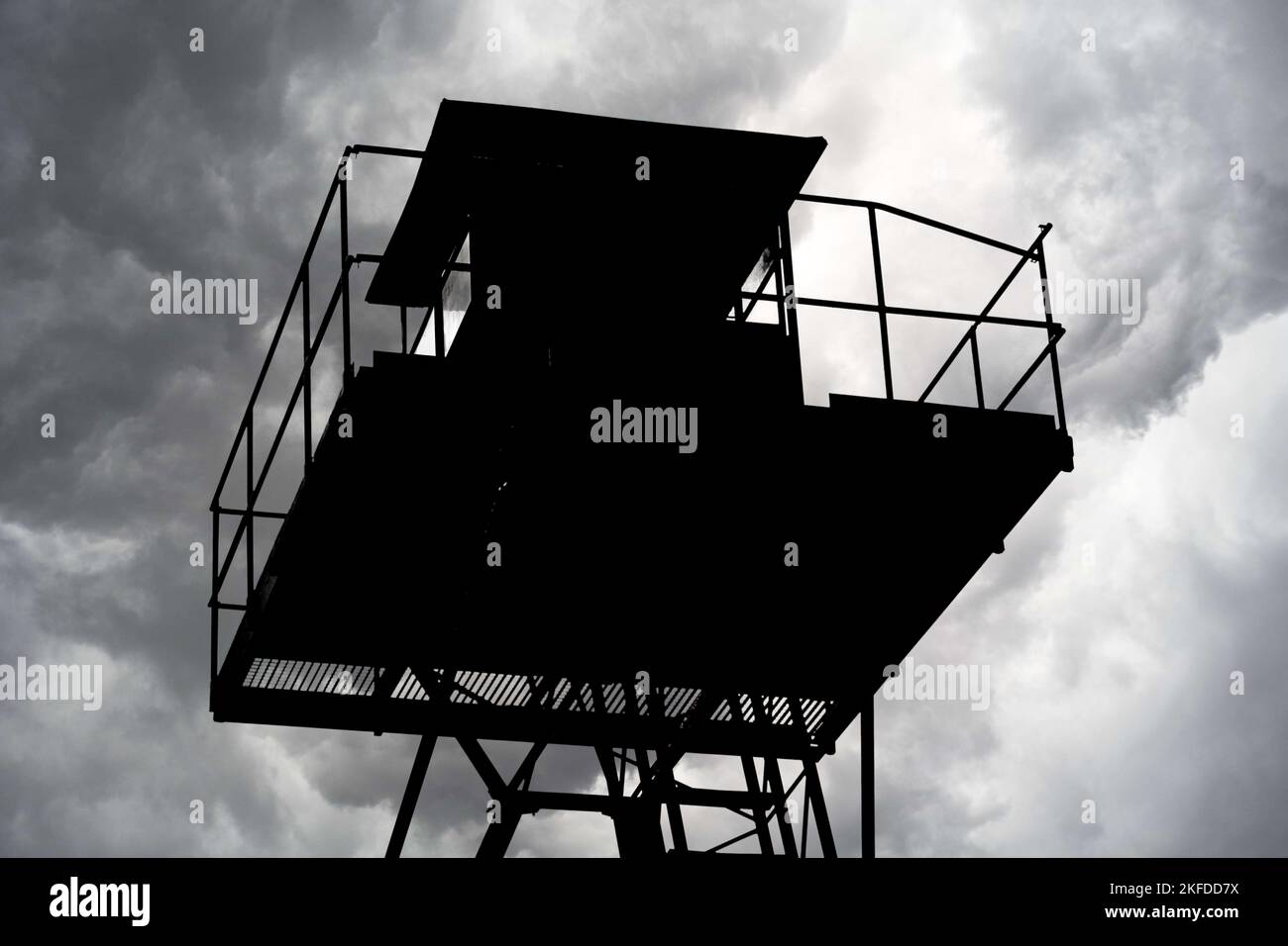 Dark silhouette of the metal structure of the watchtower, clouds in the ...