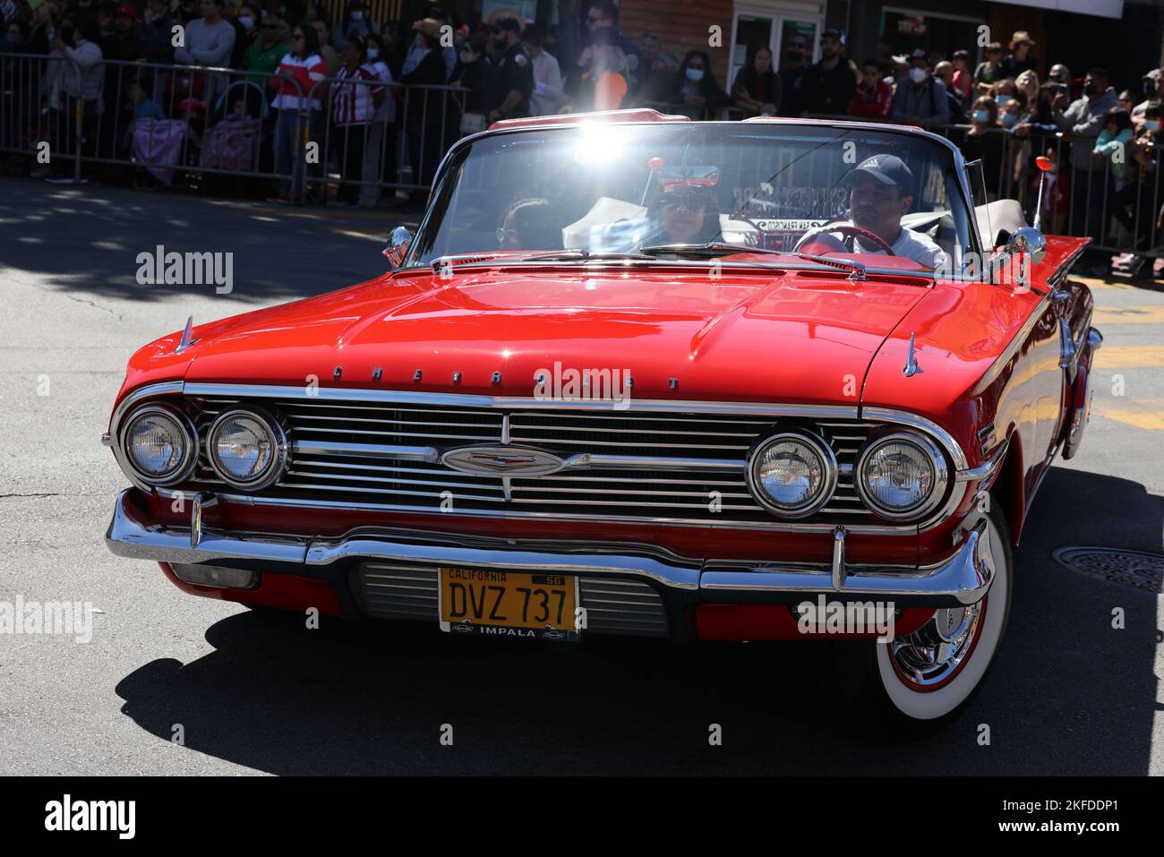 The view of a red Chevrolet classic lowrider car driving at the ...