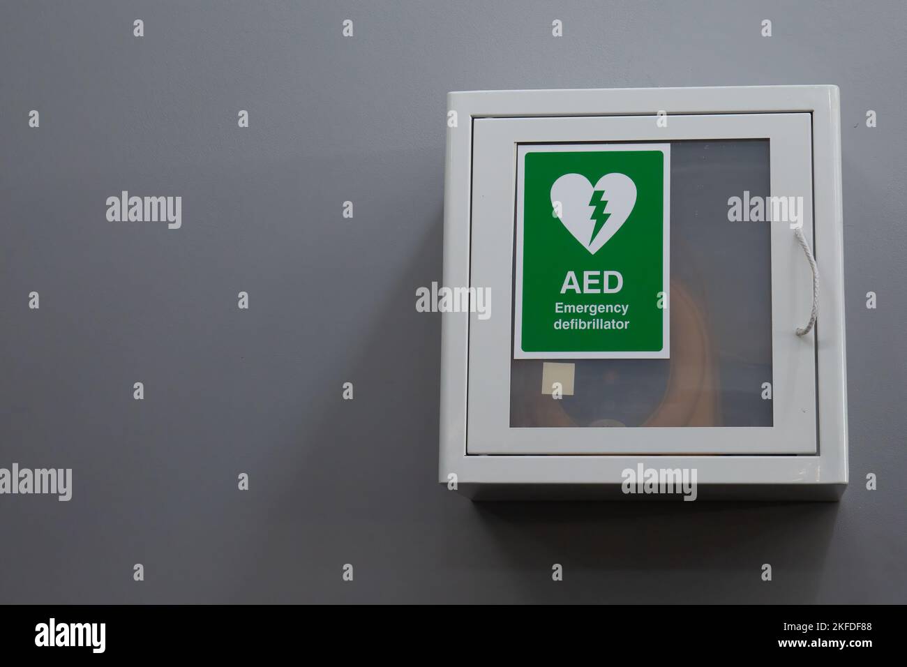 The AED emergency defibrillator sign on the emergency box on the grey ...
