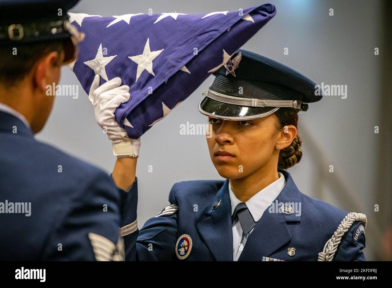An Airman from the 422d Air Base Group honor guard, holds a folded flag ...