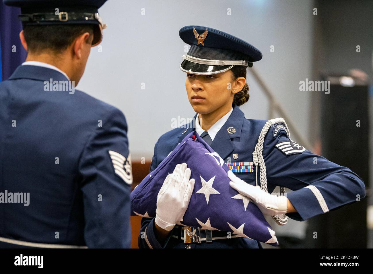 An Airman from the 422d Air Base Group honor guard, dresses a flag ...