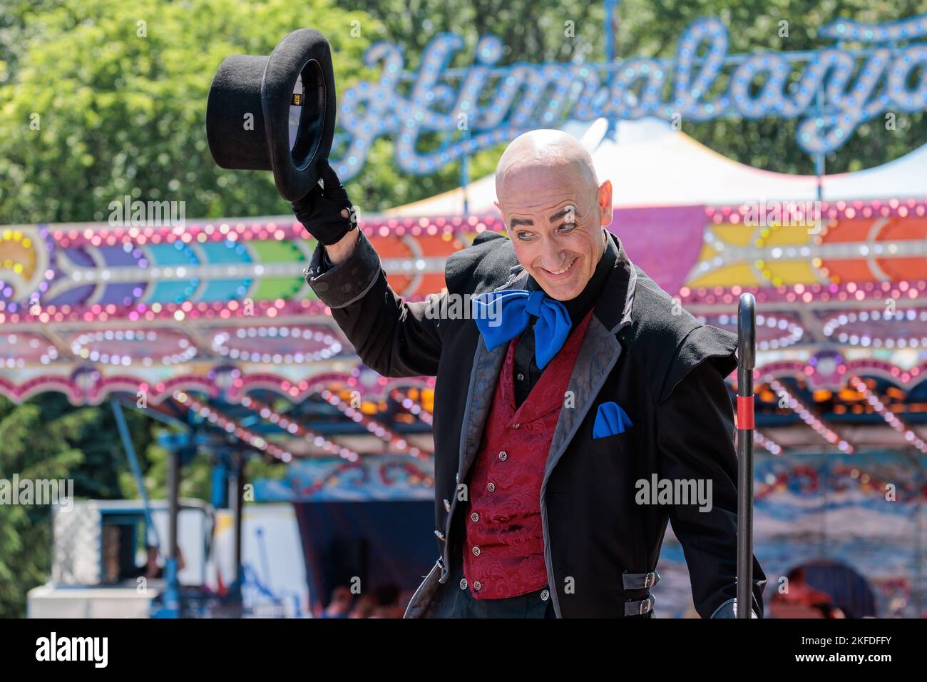 A costumed carnival performer on stilts welcomes the crowd in an ...