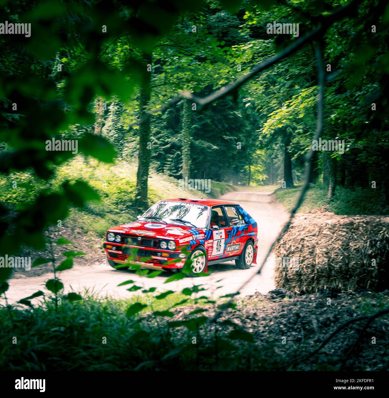 Red rally car racing in forest roads at Goodwood Festival of Speed ...