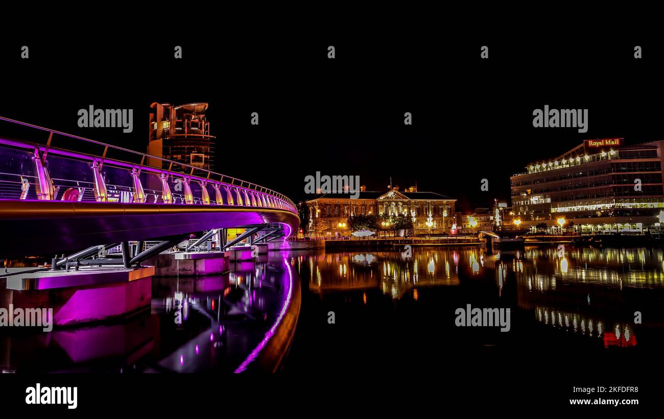 The Lagan Weir Bridge illuminated in colorful lights during night ...