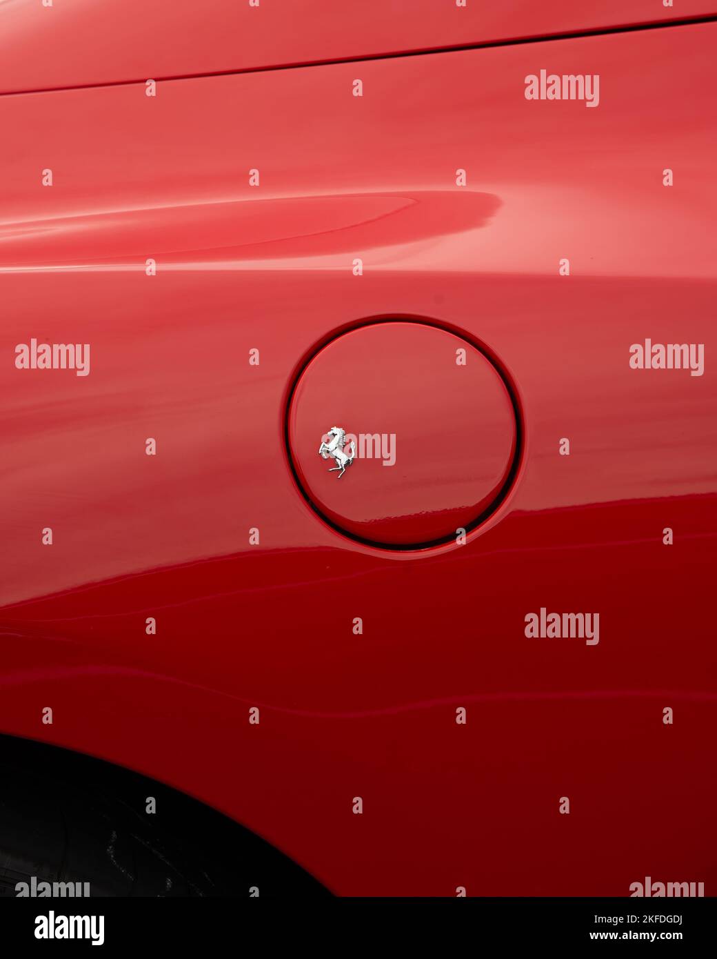 A vertical close-up shot of the luxury Italian red Ferrari gas tank ...