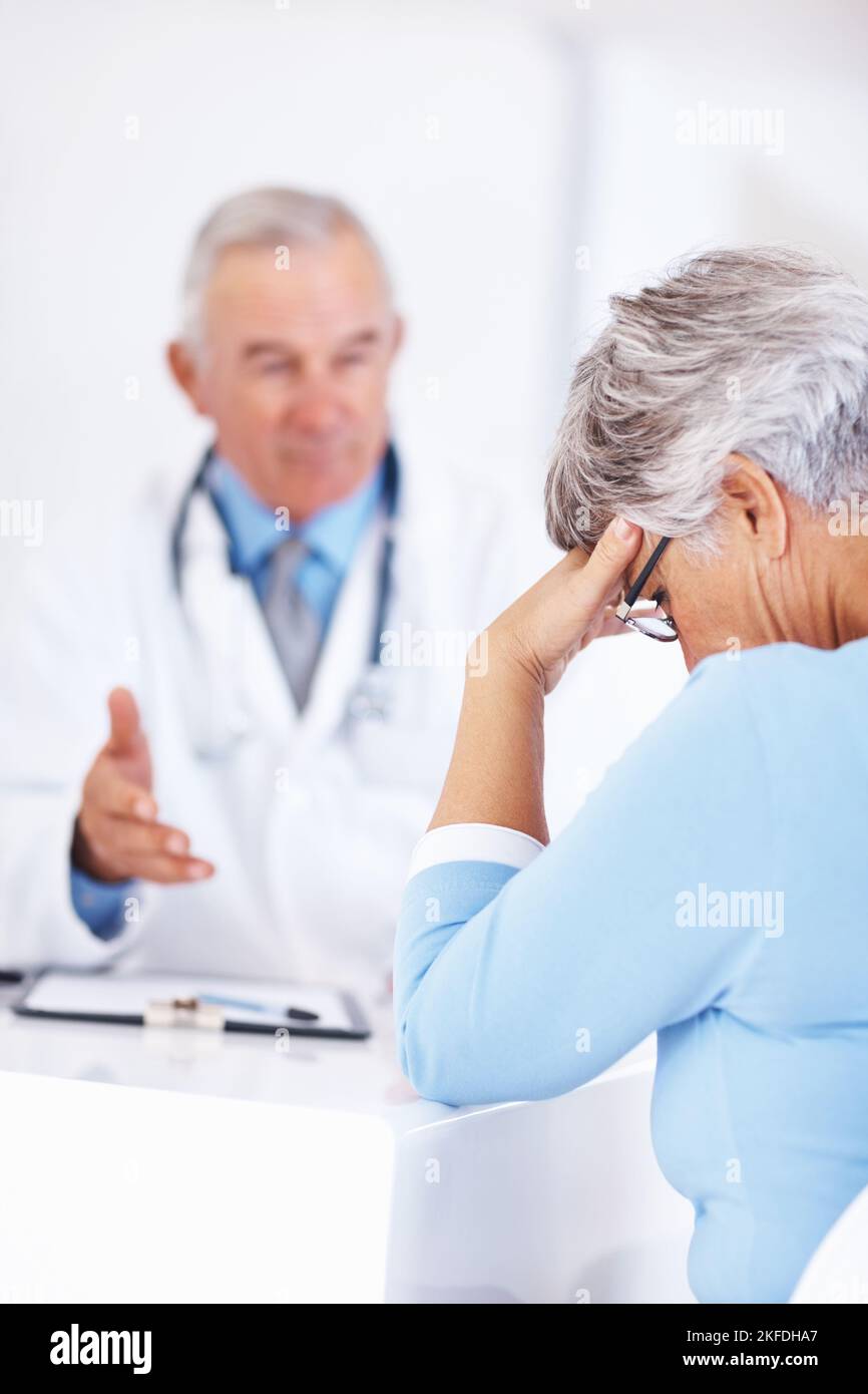 Unhappy patient with doctor. Mature doctor discussing medical report ...