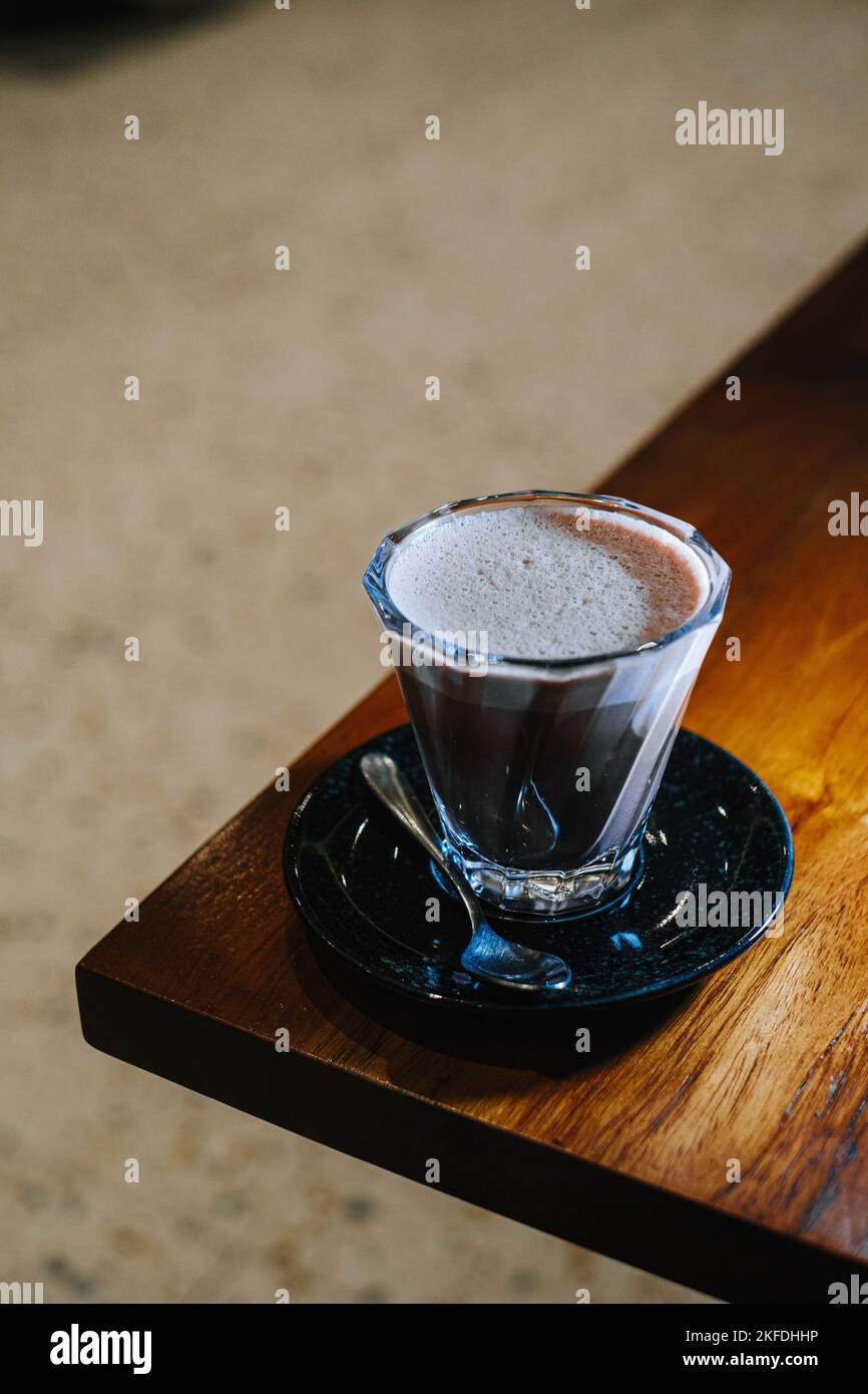 Portrait or vertical shot of a glass of hot chocolate in the wooden ...