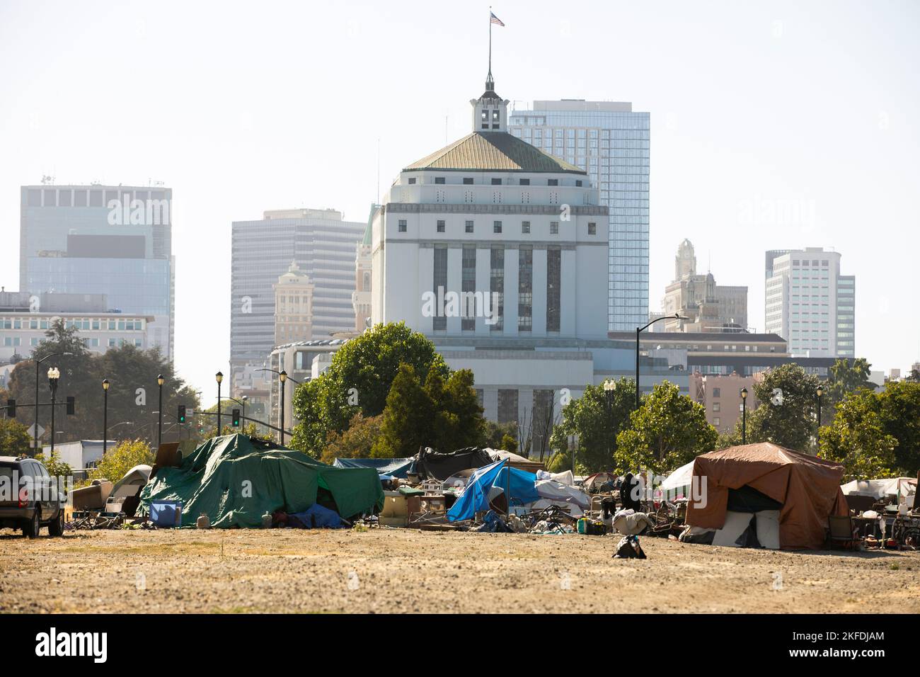 A homeless encampment frames the skyline of downtown Oakland ...