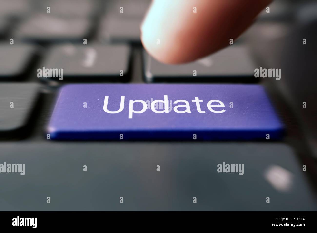 Customized concept with computer enter button on keyboard: Update. A male finger presses a color ...