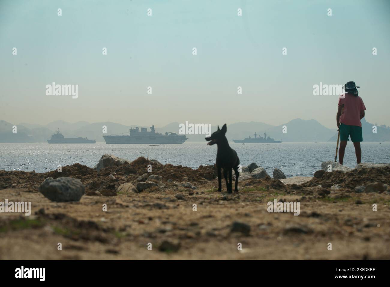 GUANABARA BAY (Sept. 10, 2022) A fisherman watches ships waiting to be ...
