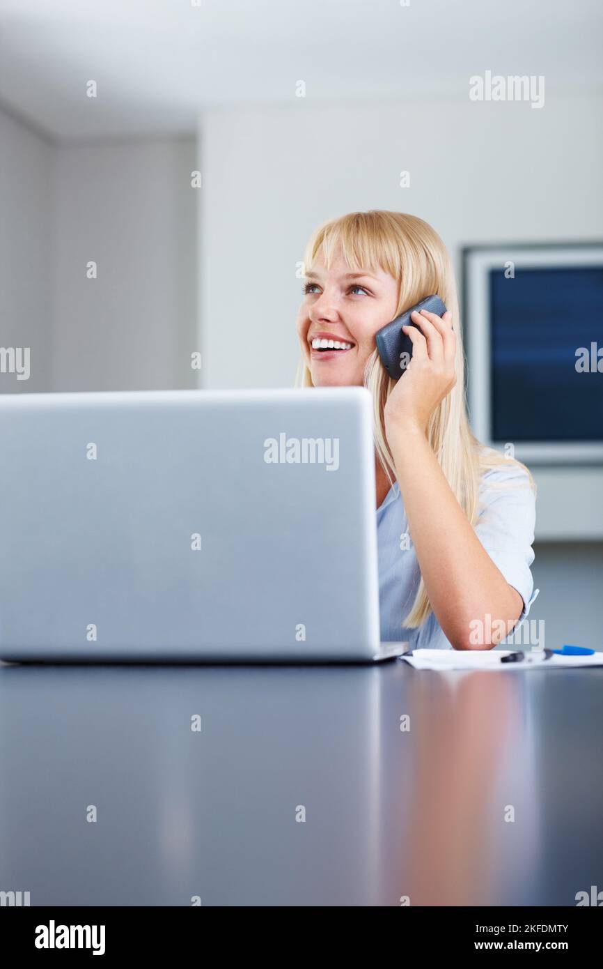 Woman using laptop and mobile phone. Female executive talking on ...