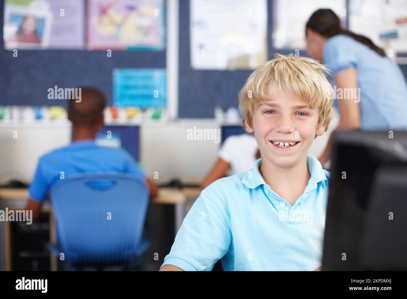 Happy in his computer class. Portrait of a young schoolboy in computer ...