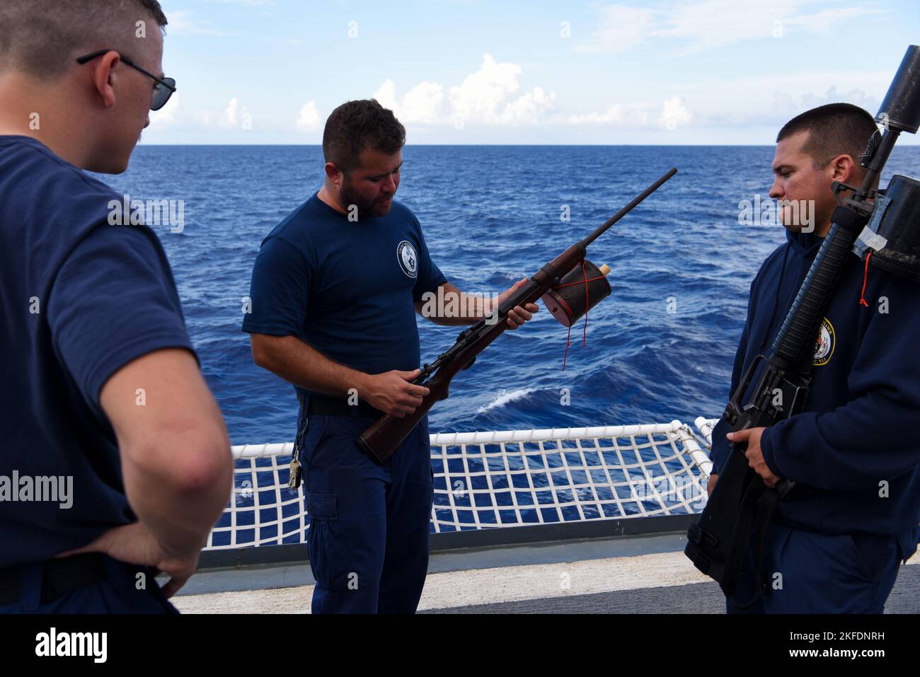 U.S. Coast Guard Petty Officer 3rd Class Randal Solis, center, gunner’s ...