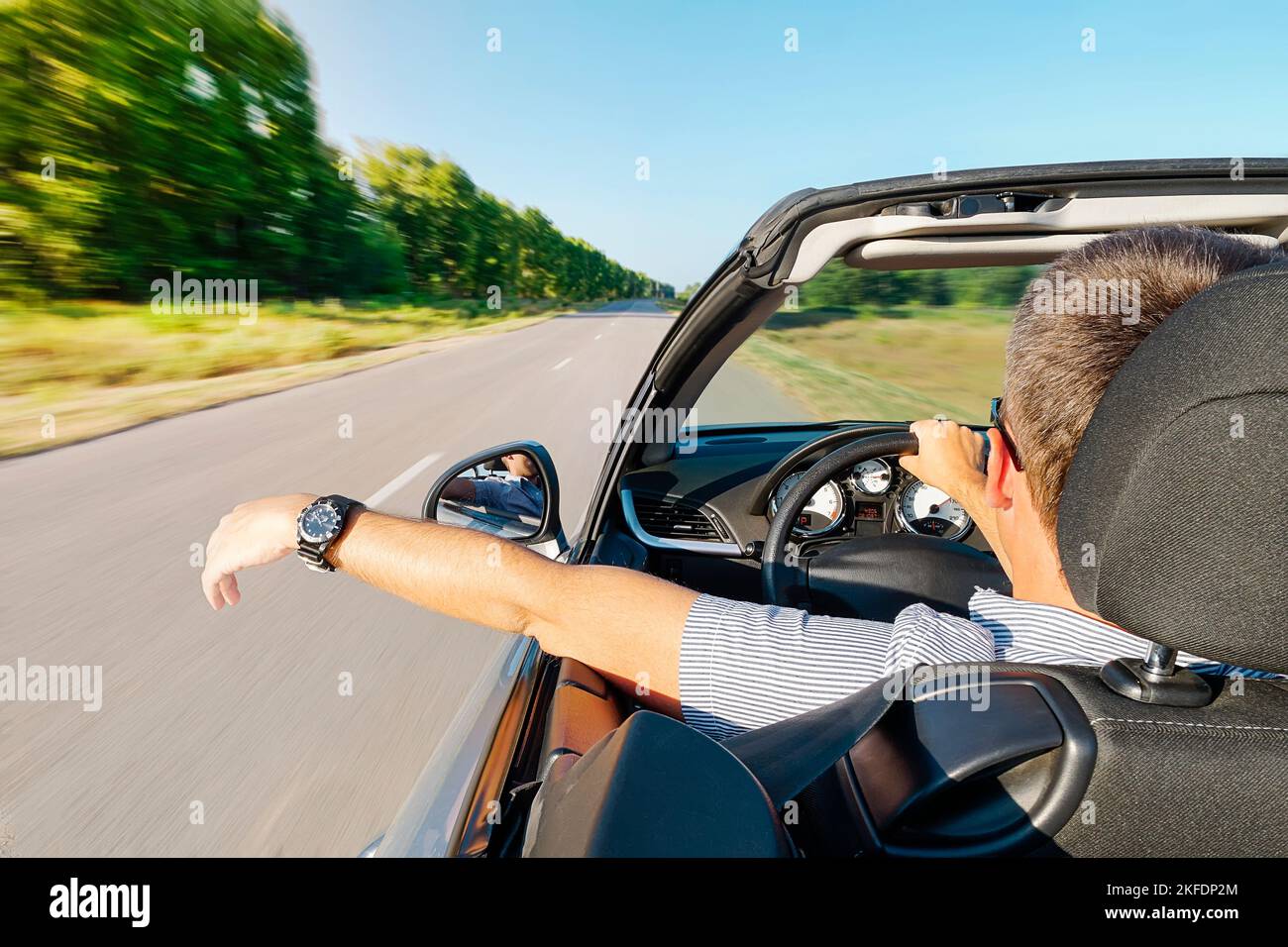 calm happy successful man sit in the car hand is driving the car on the ...