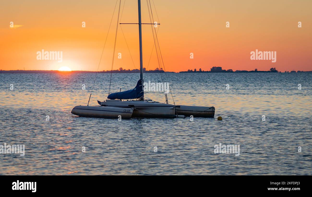 A scenic view of boat sailing in a tranquil sea at sunset Stock Photo ...