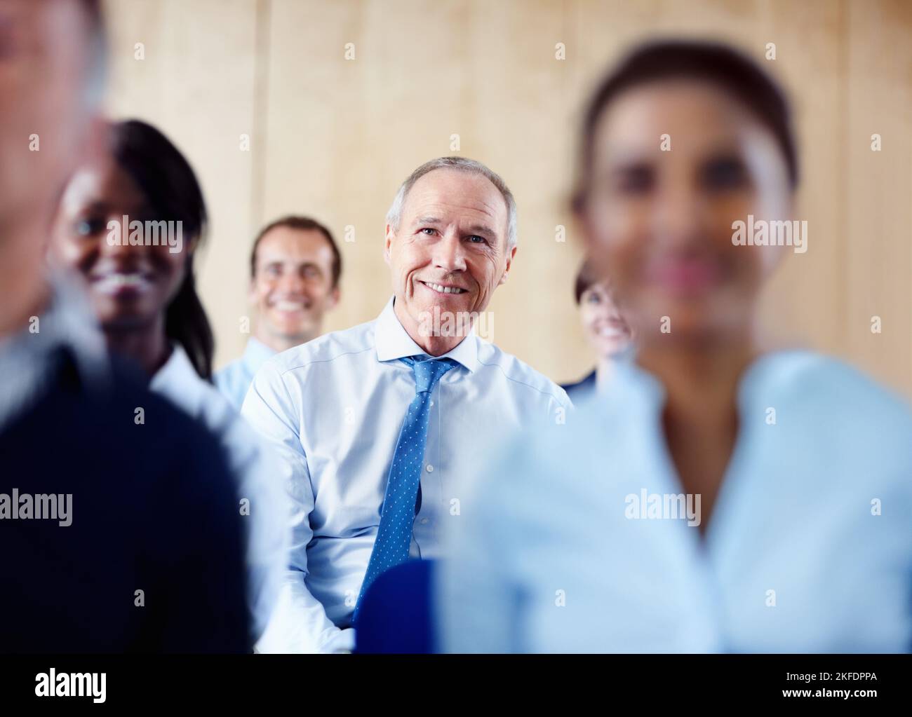Senior executive sitting with group. Focus on senior Business man ...