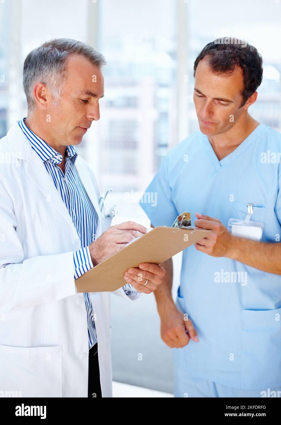 Doctor discussing prognosis with nurse. Doctor and nurse discussing ...