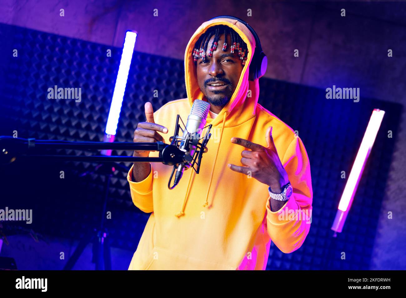 Young African performer recording his new track in recording studio ...