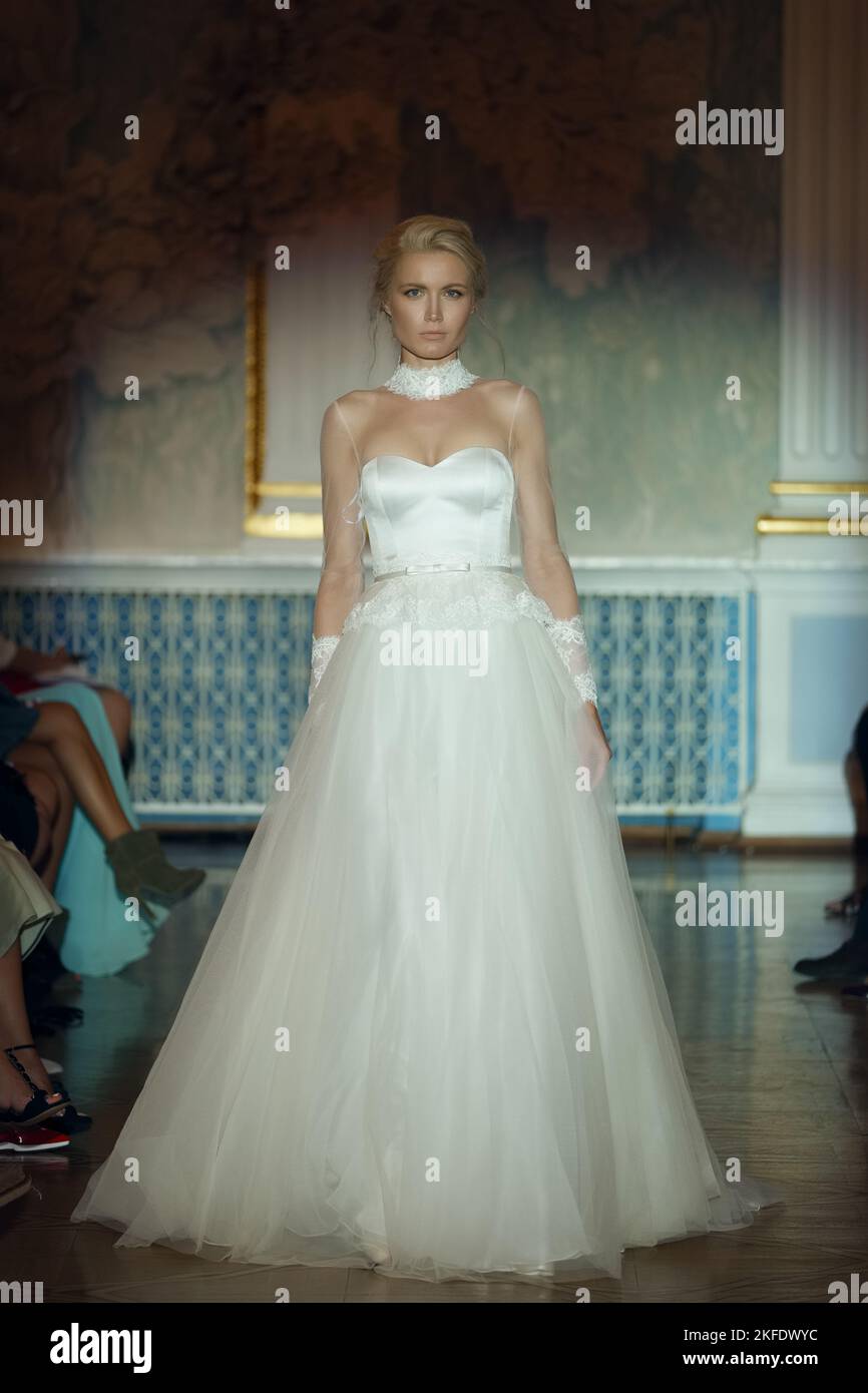 Attractive fashion model on stage in spotlight. Wedding makeup and hair ...