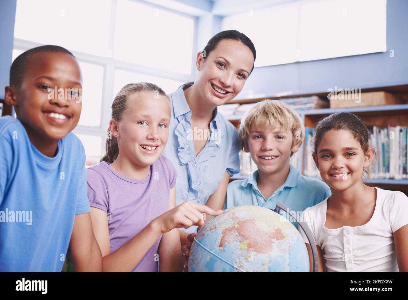 We love the earth. A pretty young geography teacher teaching her ...