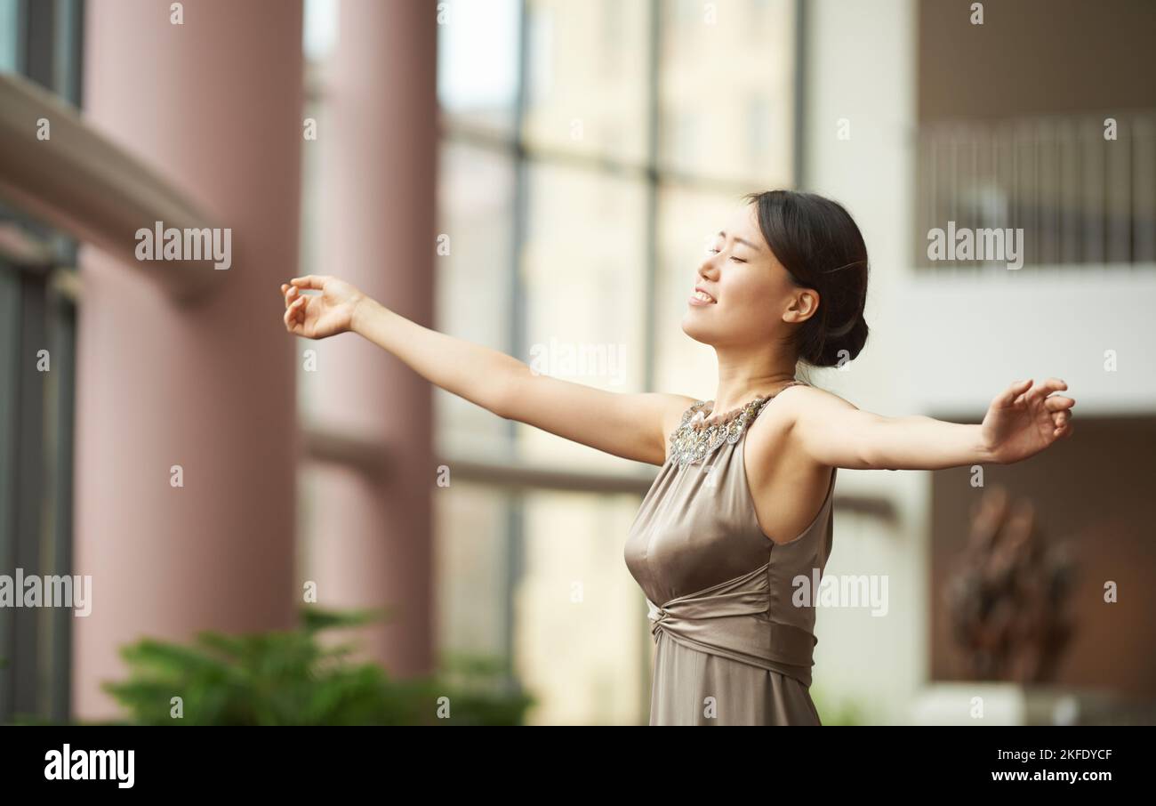 Embrace the day. an elegantly dressed young woman dancing through a ...