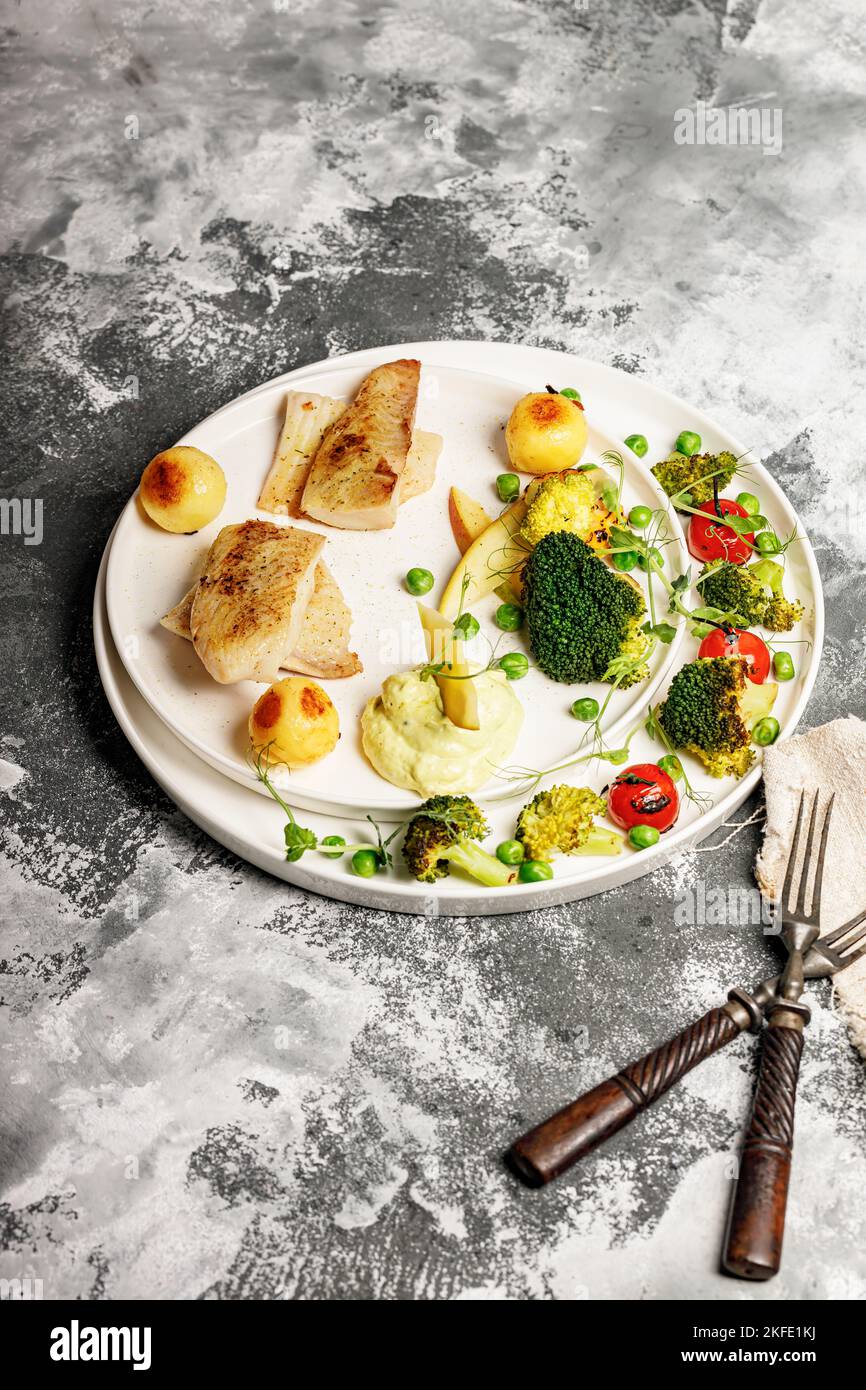 Baked sea fish fillet with vegetables. Tilapia fillet with broccoli ...
