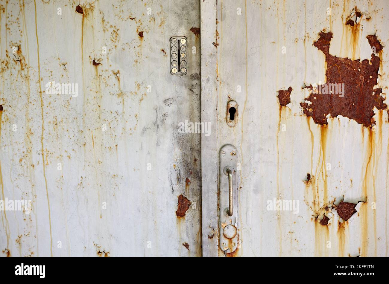 The old door to the building. Painted metal door with rust spots and ...