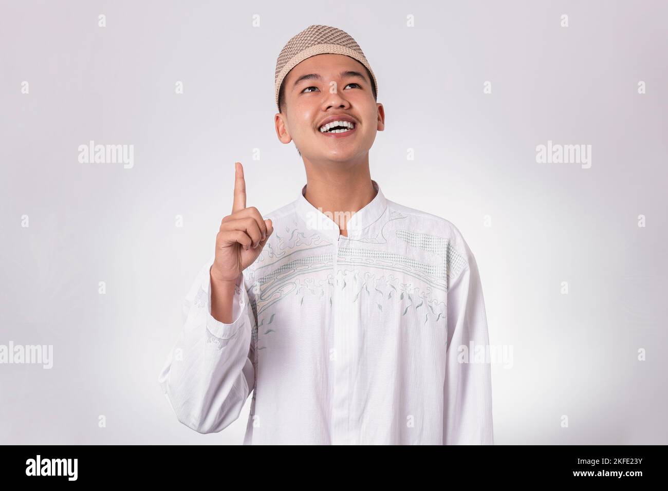 Smiling Asian muslim man happy celebrating Eid Al-Fitr isolated white ...