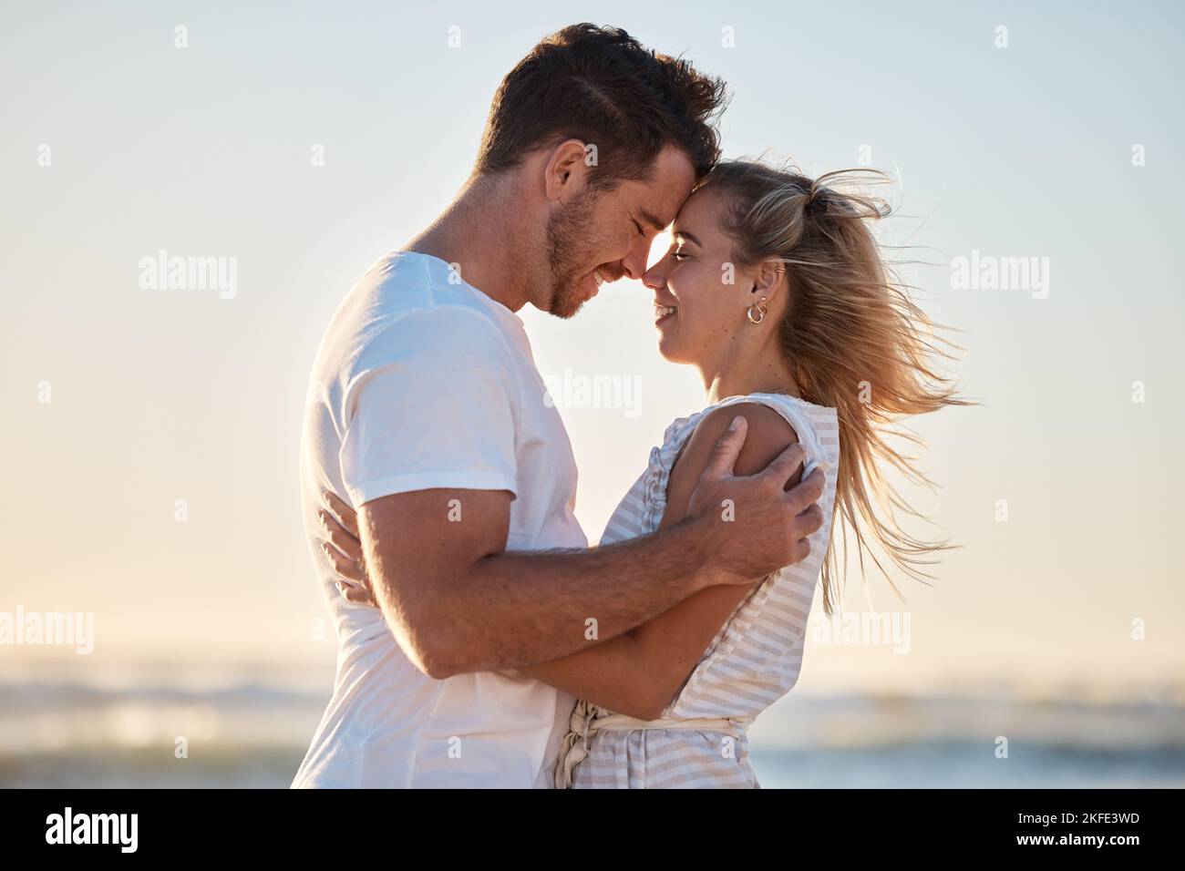 Love, happy hug and couple relax at beach with happy smile, affection ...