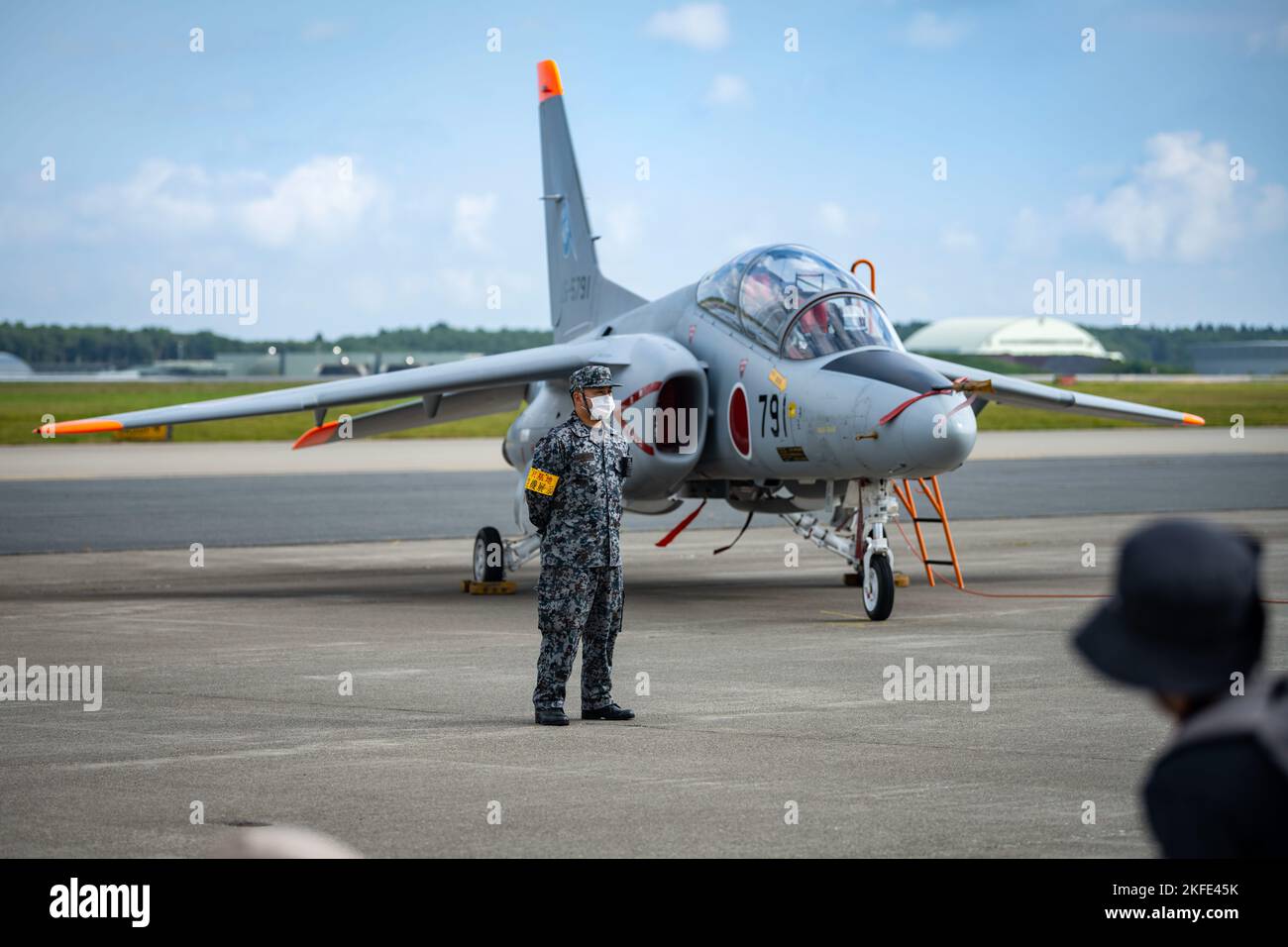 A Japan Air Self-Defense Force (JASDF) member stands in front of a ...