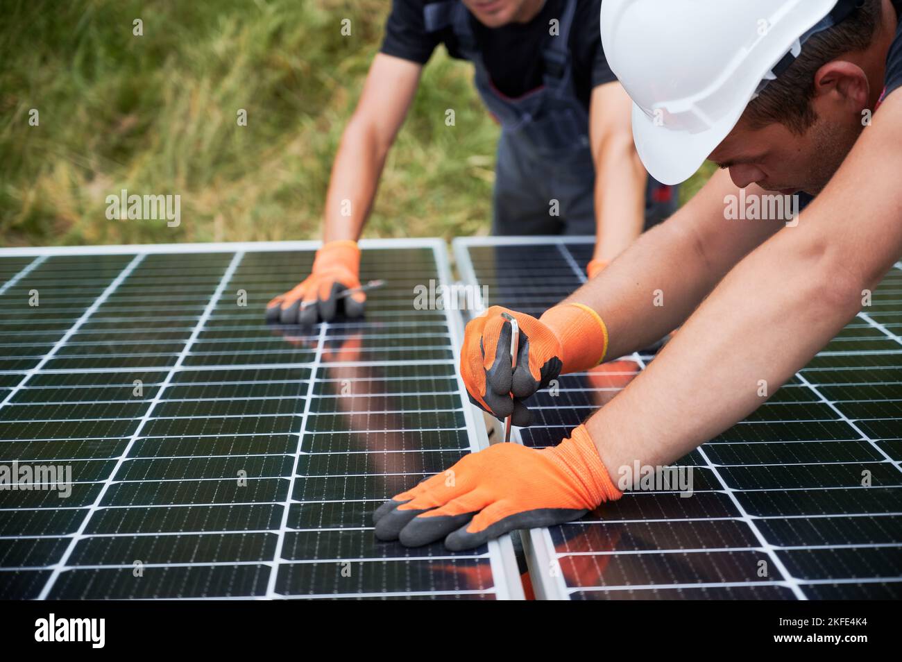 Male workers building photovoltaic solar panel system outdoors. Men ...