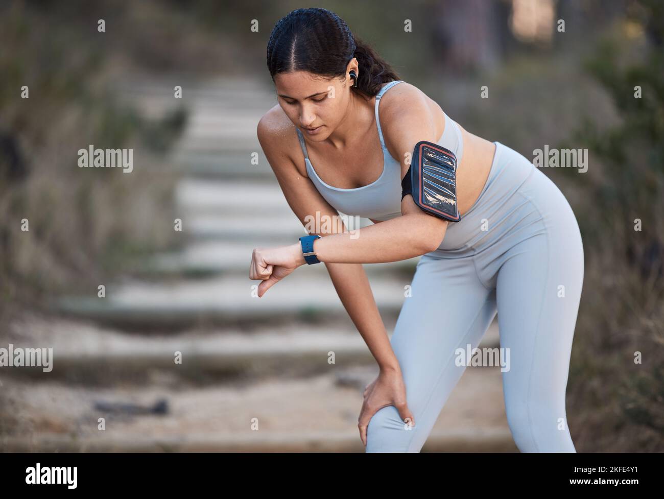Fitness, runner and woman running with smartwatch, check time and ...