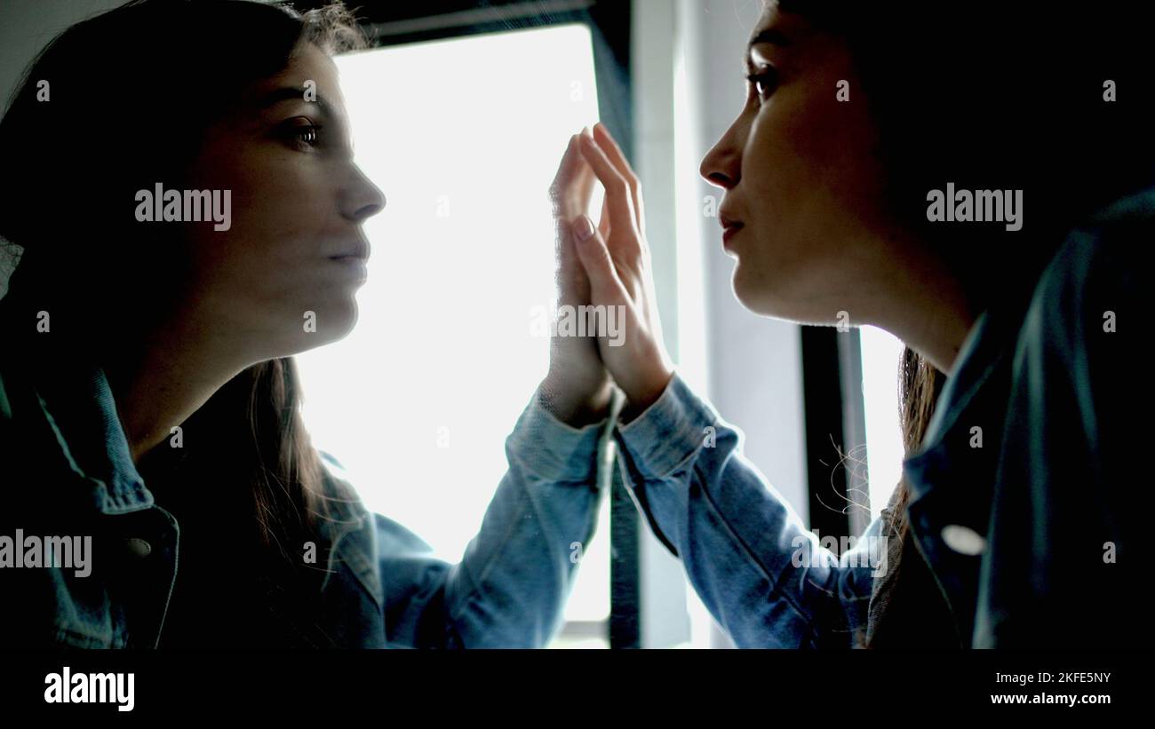 Woman looking at mirror reflection facing your fears concept Stock Photo - Alamy