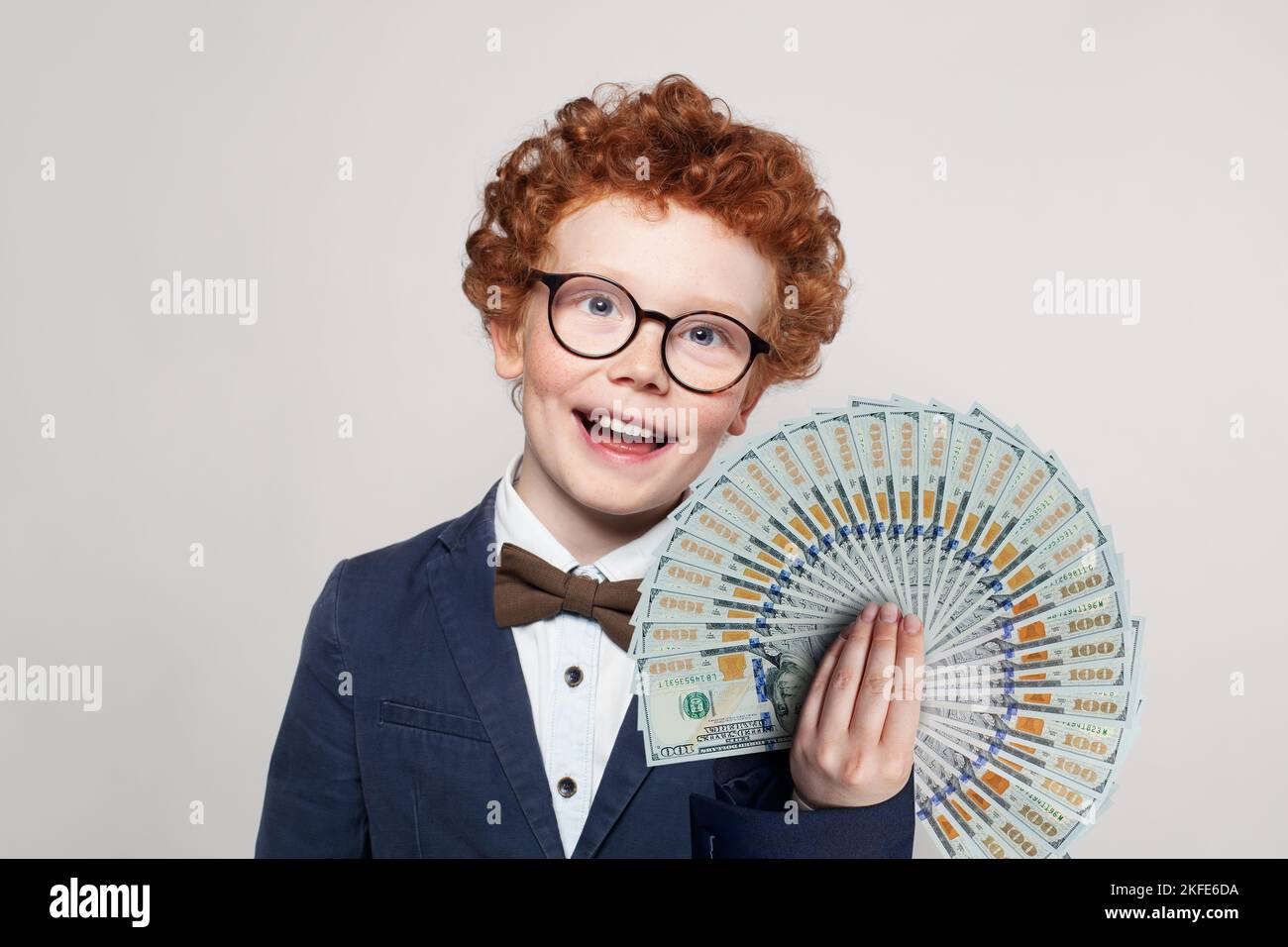 Happy child smart student boy in glasses and suit portrait with money ...