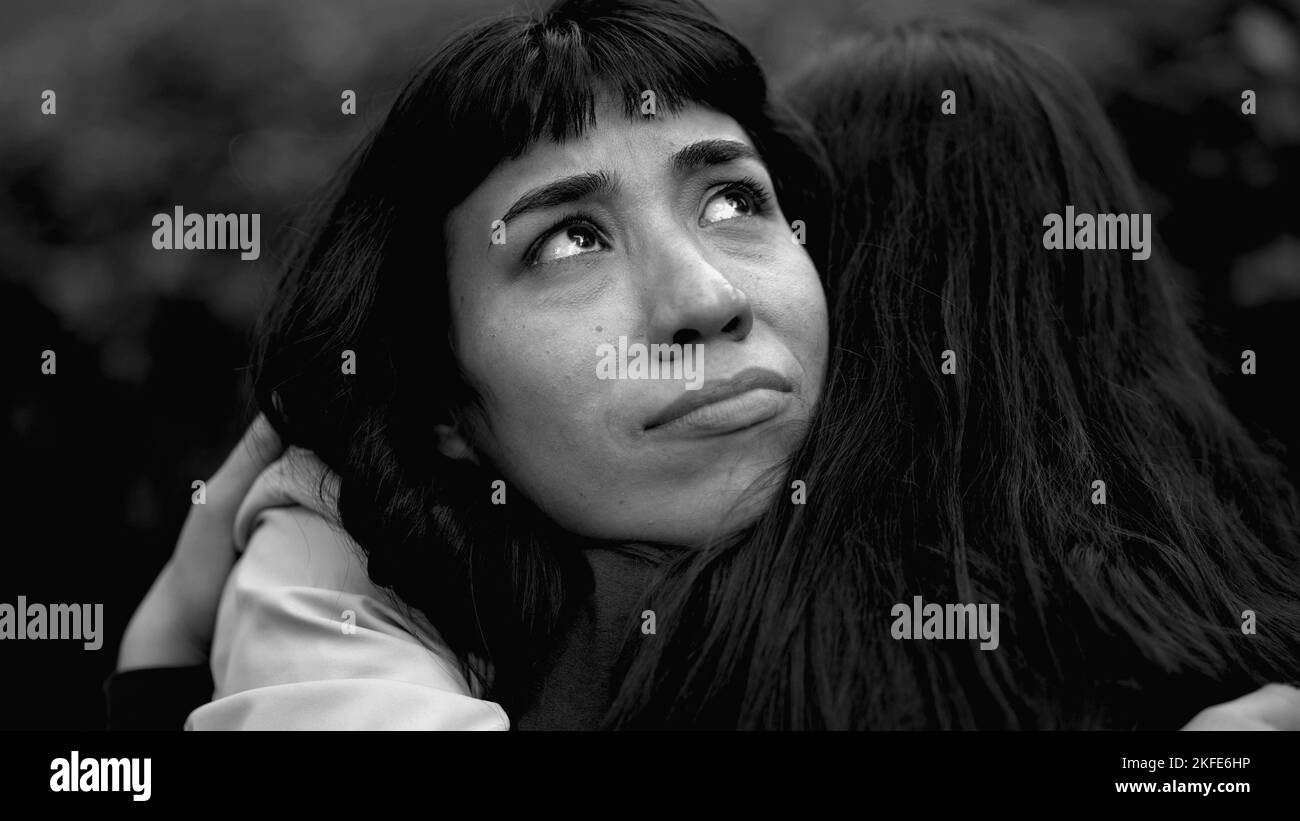 A depressed latin woman having the support of friend. Two women hugging ...