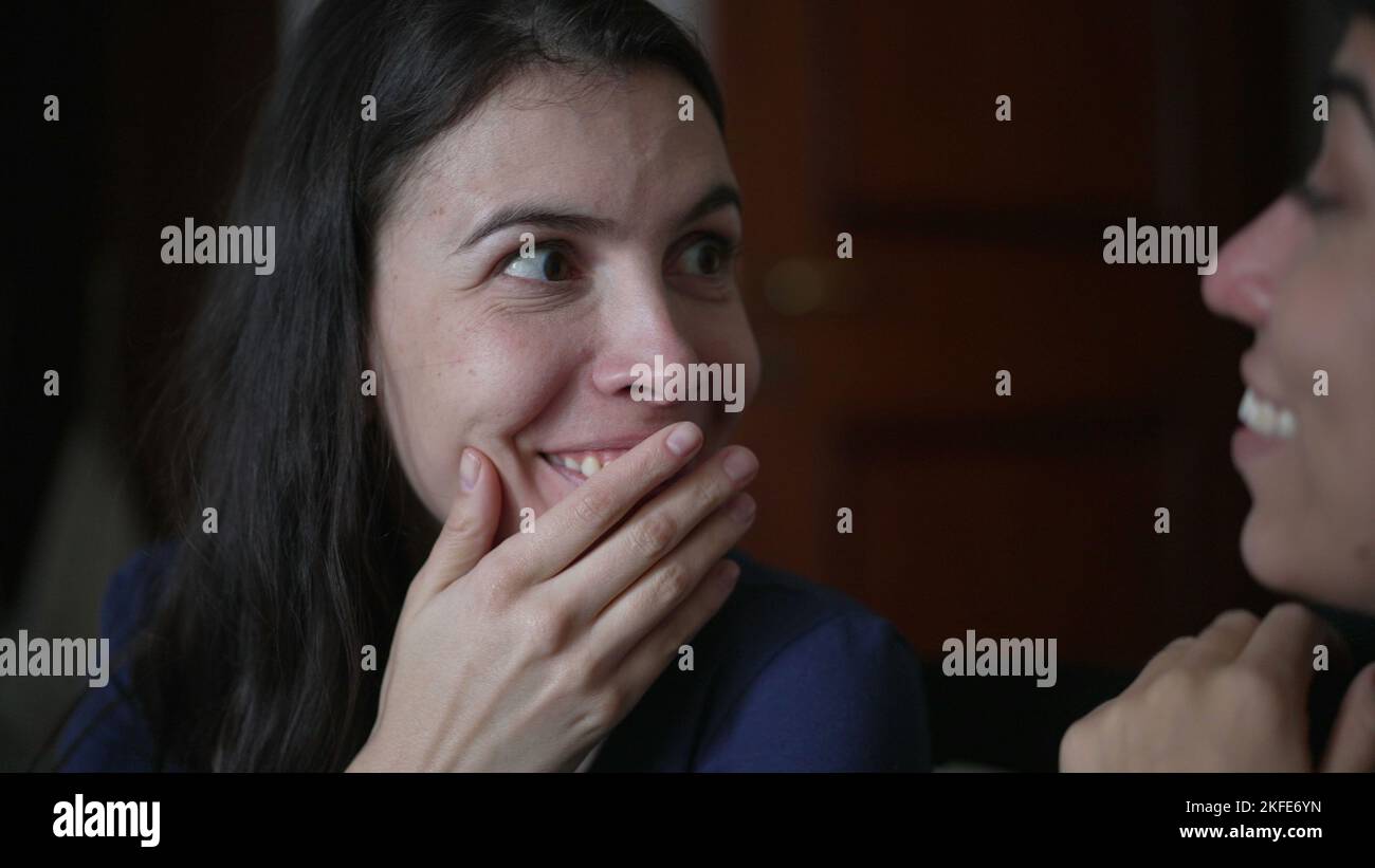 Friend telling secret to woman ear whispering. Young woman shock ...