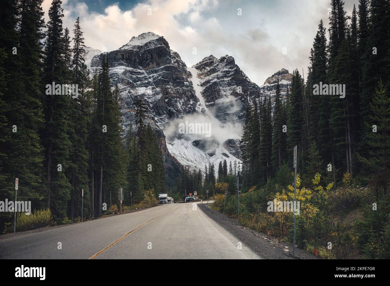 Scenic road trip driving through rocky mountains and pine forest near Moraine Lake at Banff ...