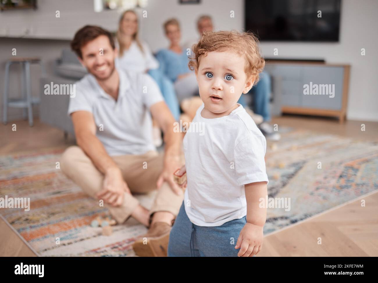Baby, portrait and play in living room with family, curious and energy ...