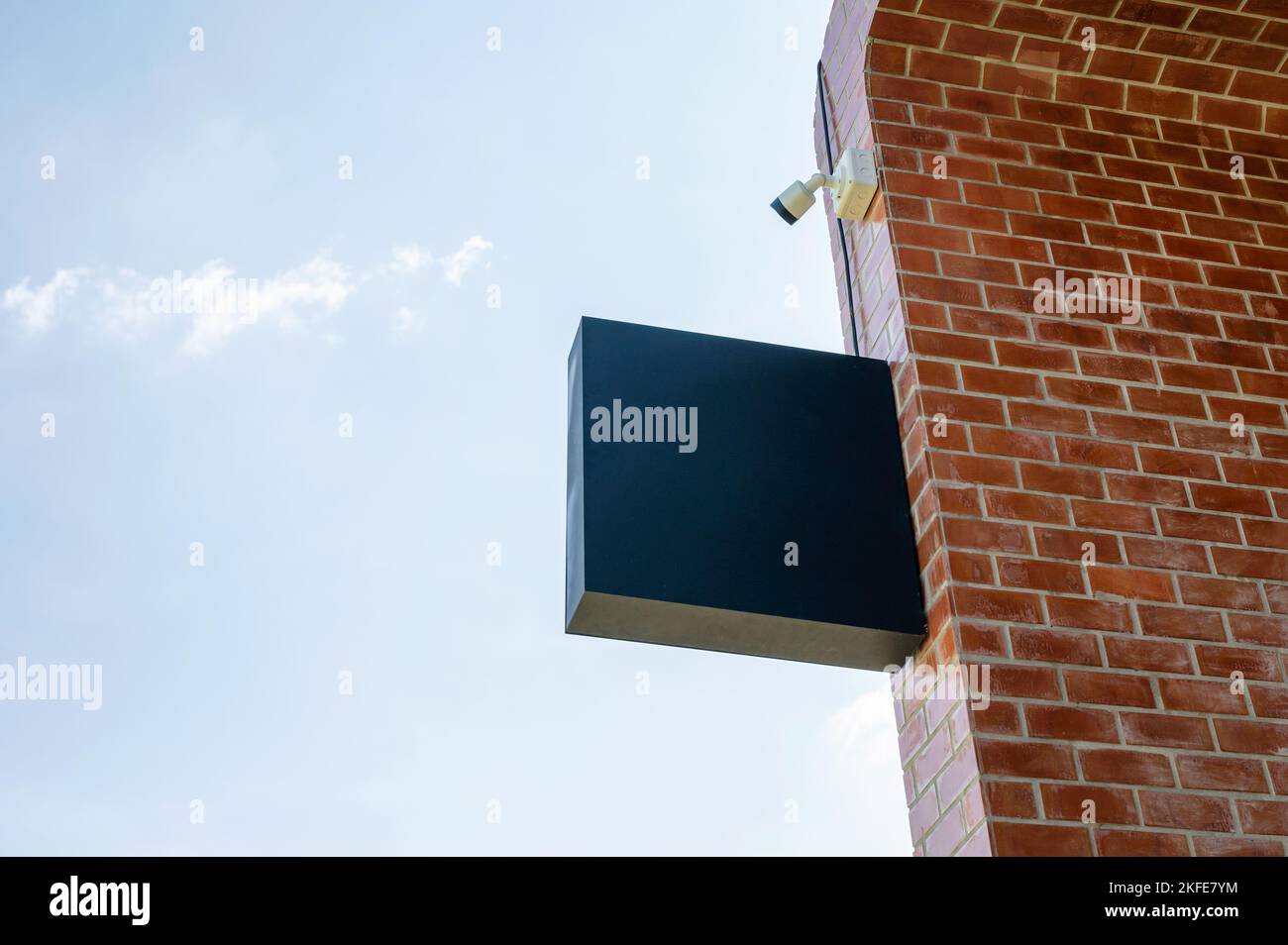 Empty shop signage with CCTV security camera hanging on brick wall and ...