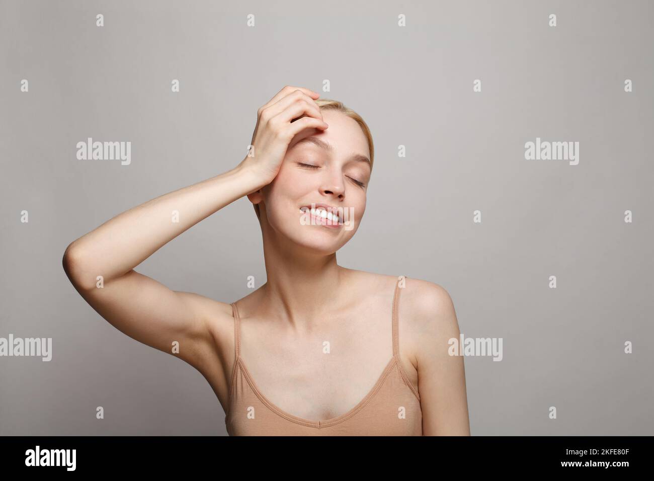 Pretty nice woman holding her head with a laugh looking to the side ...