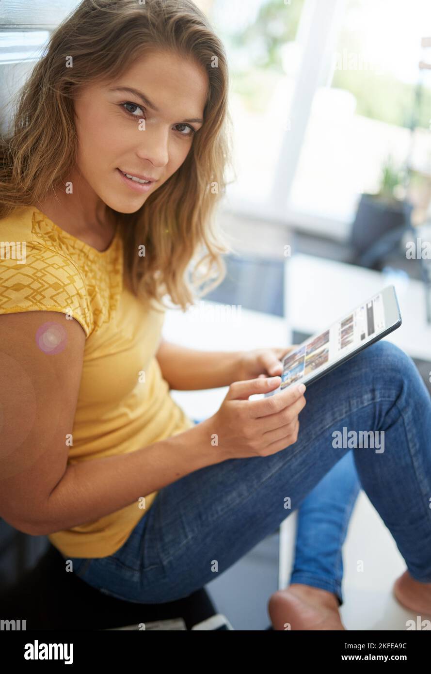 Living wirelessly at home. Portrait of an attractive young woman ...