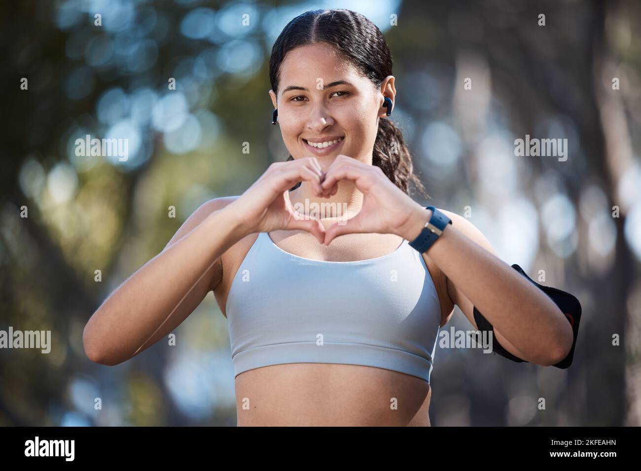 Fitness portrait, heart hands and woman in nature with sign for ...