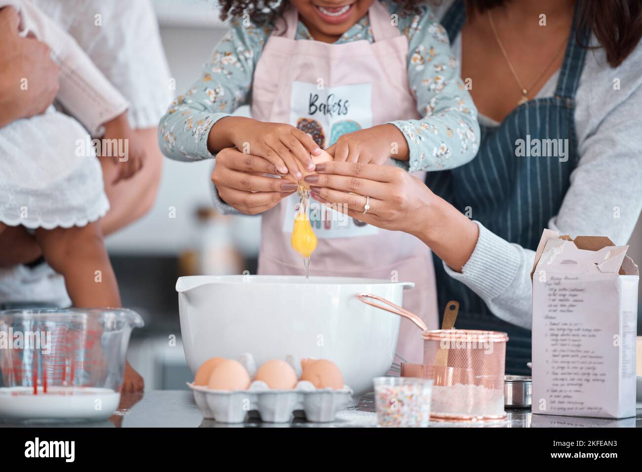 Baking, egg and mother helping her child in the kitchen to bake a cake ...