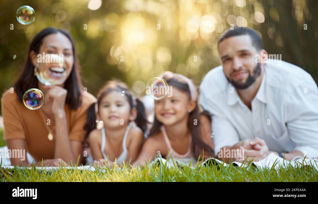 Bubbles, family and relax on grass at park, nature or outdoors on ...