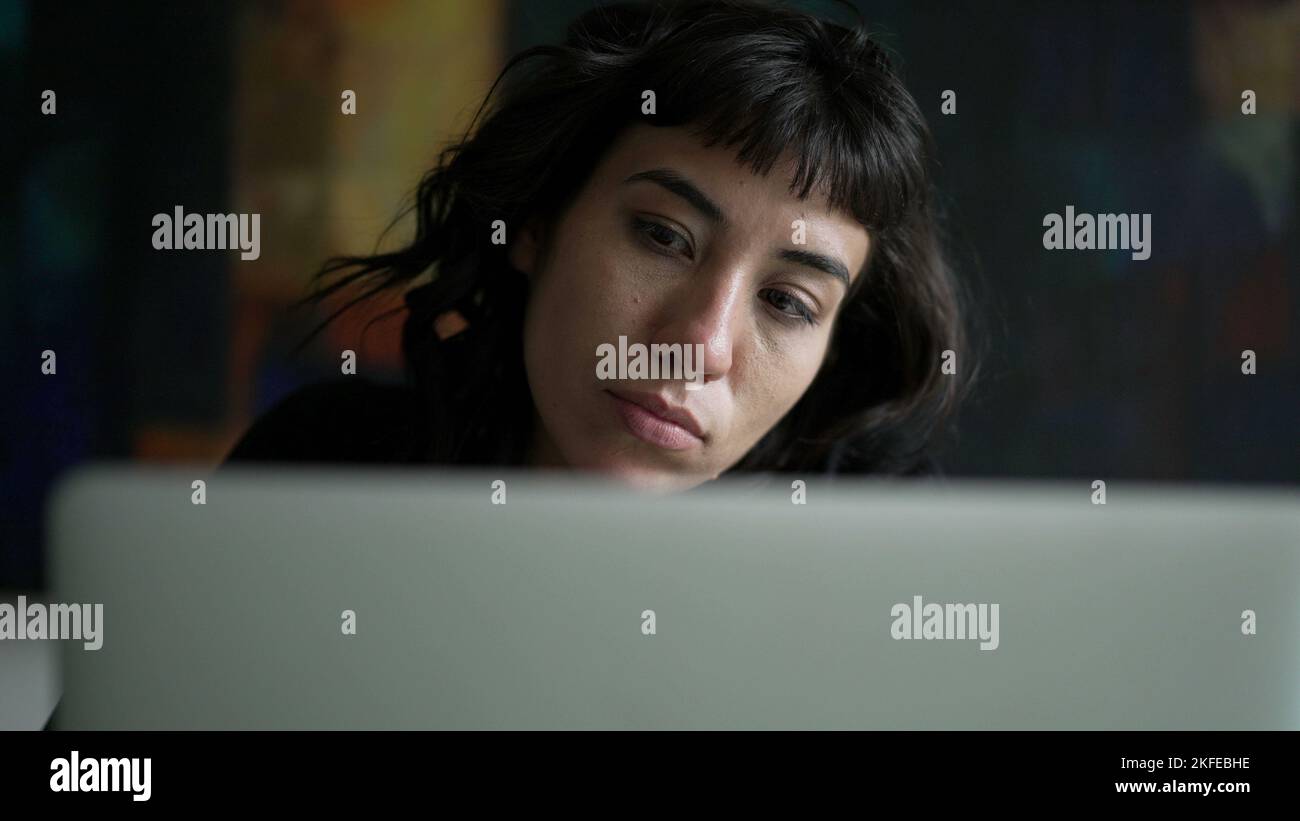 One pensive hispanic woman in front of laptop. A thoughtful latin ...