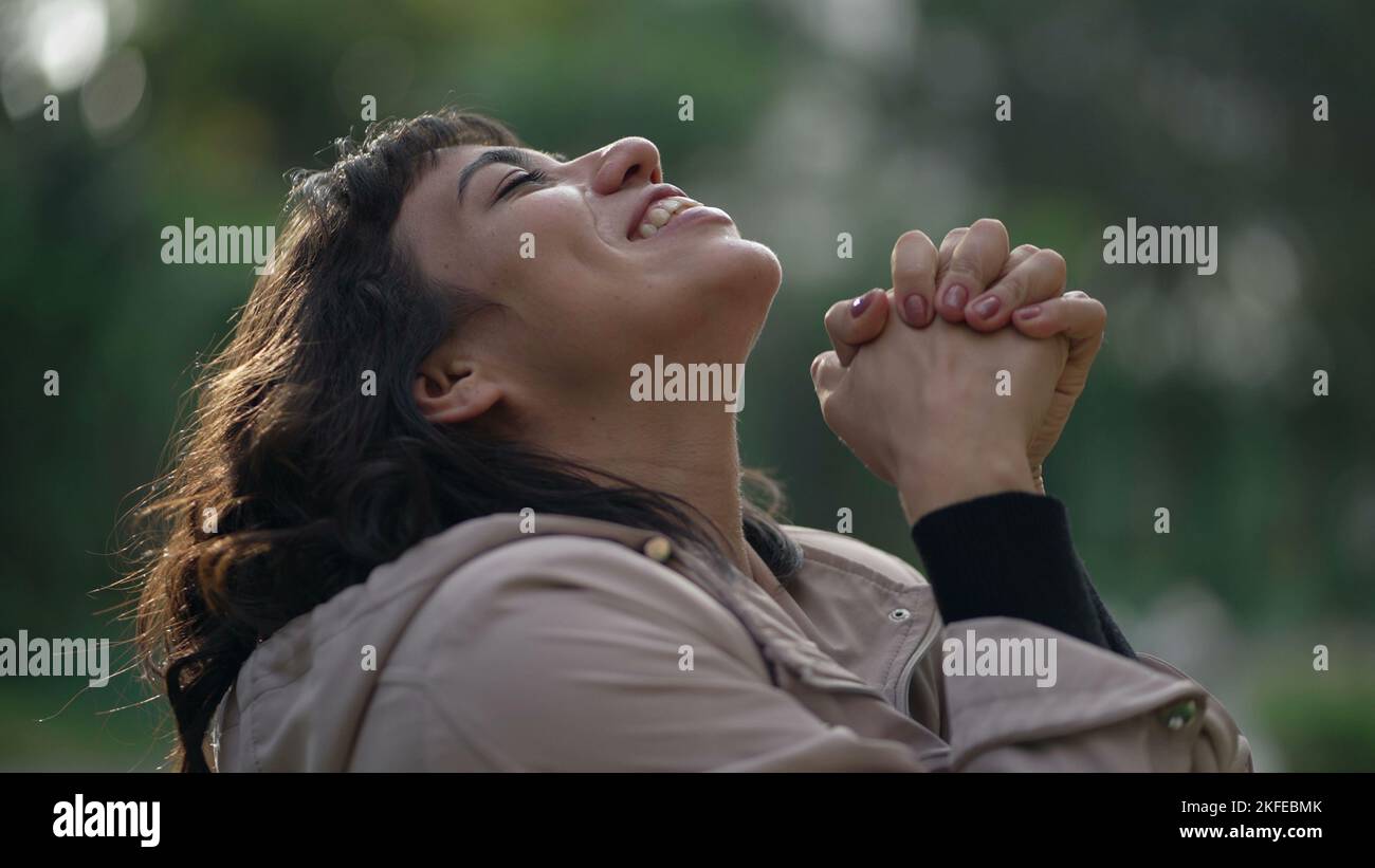 Religious thankful young woman raising arms in air celebrating life in ...